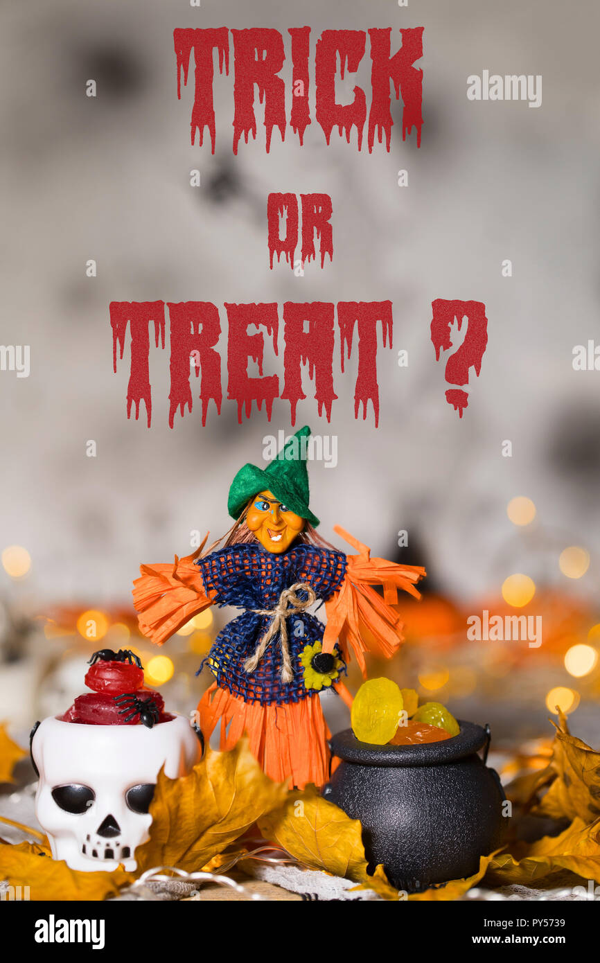 Trick or treat! Handmade witch in a hat. Candles in cauldrons for ...