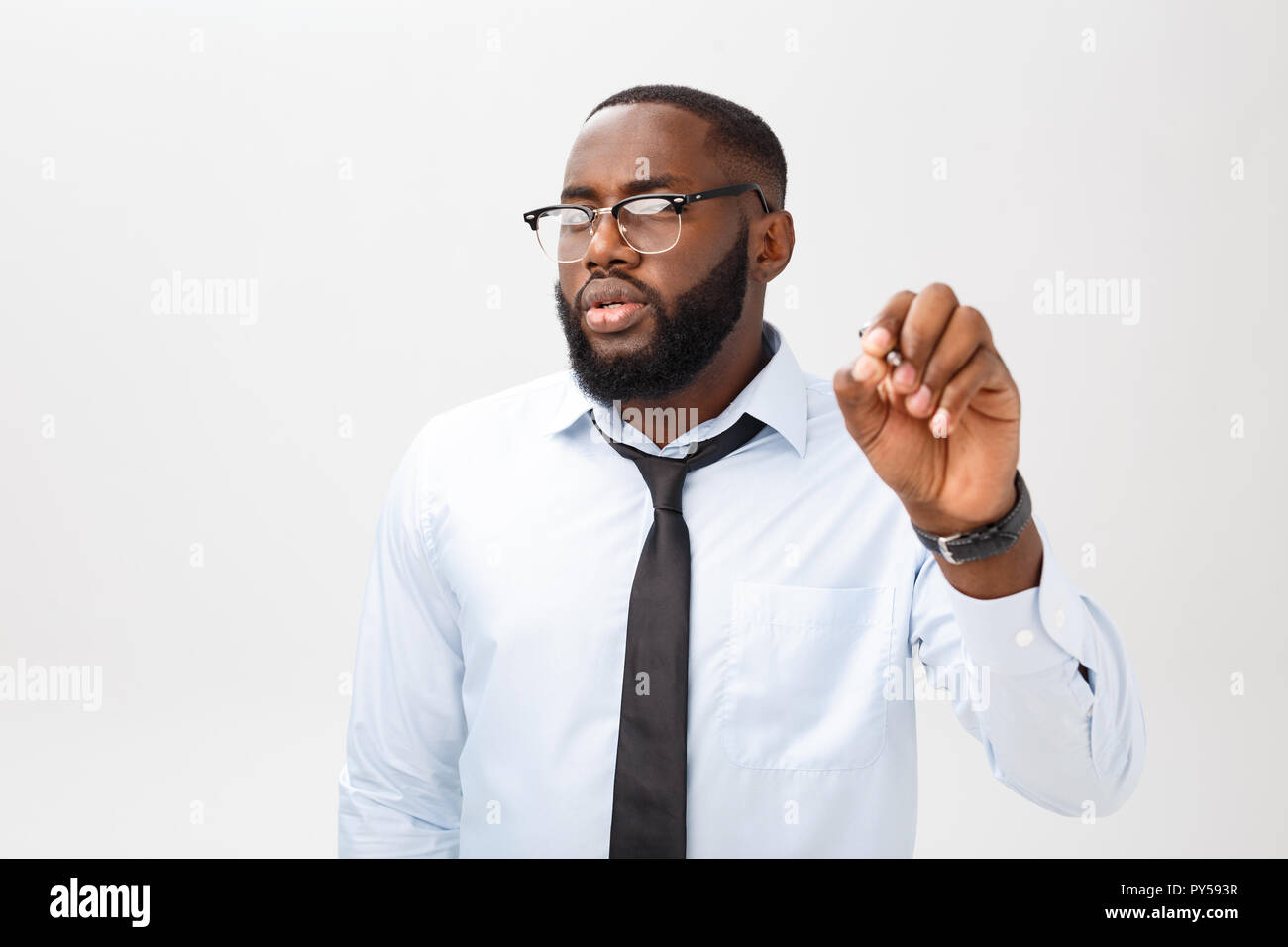 Young African american business man writing something on glass board ...