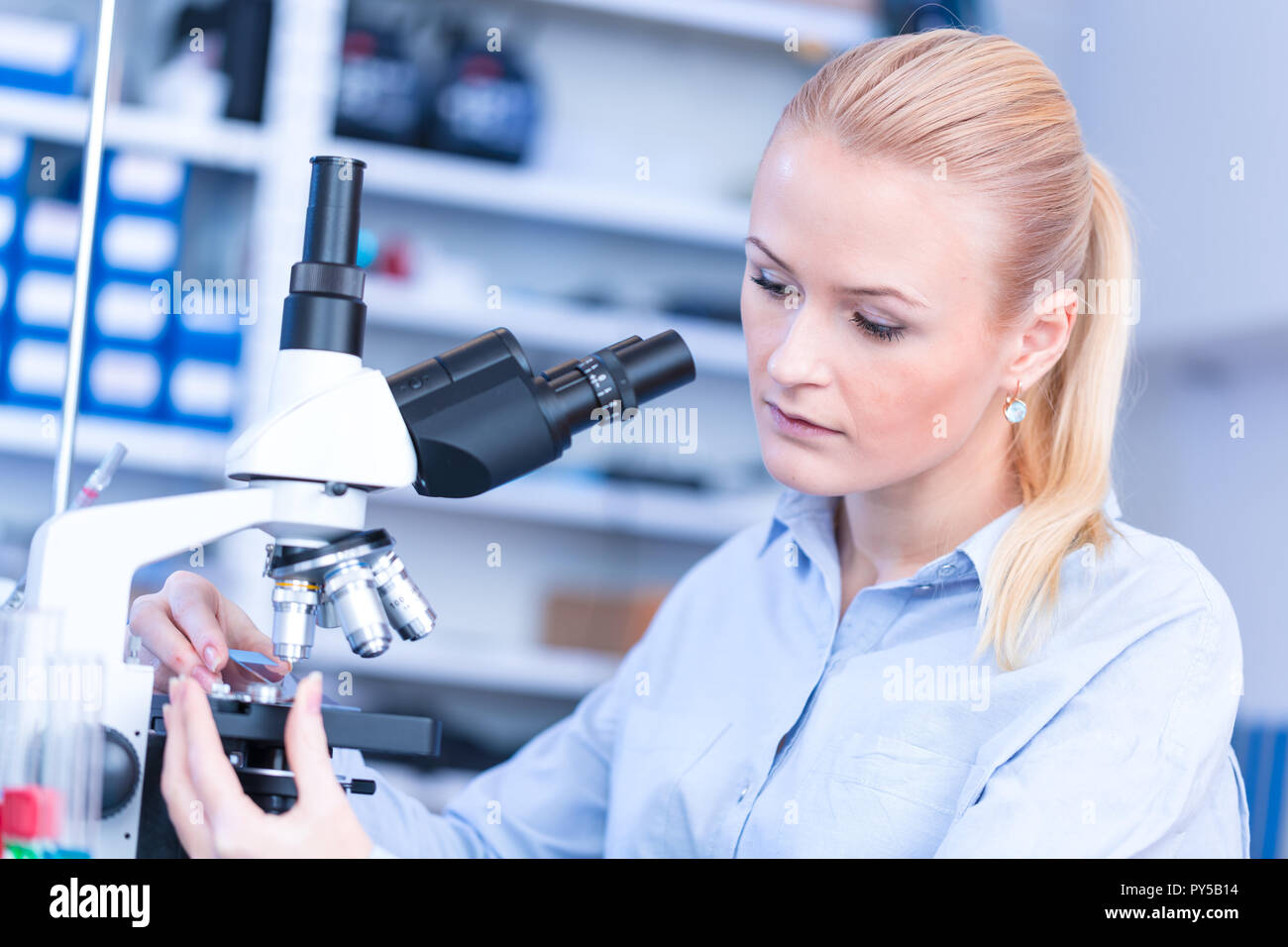 Girl with a slide for the microscope University Hospital. Attractive ...