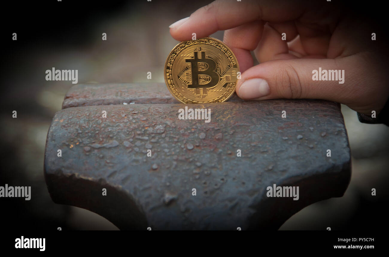 Bit coin in vice with holding hand Stock Photo - Alamy