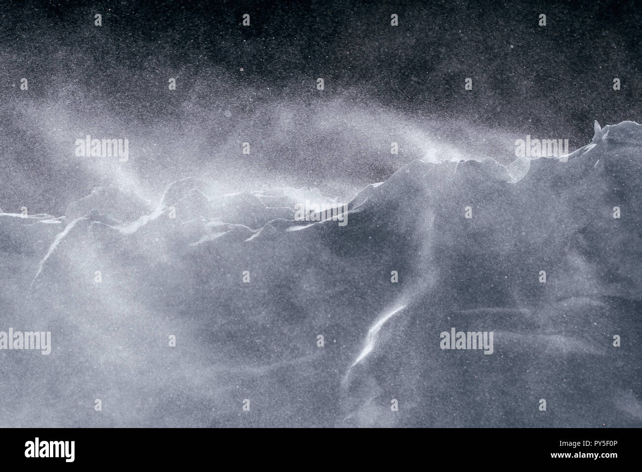 Wind blows fresh snow over an embankment Stock Photo - Alamy