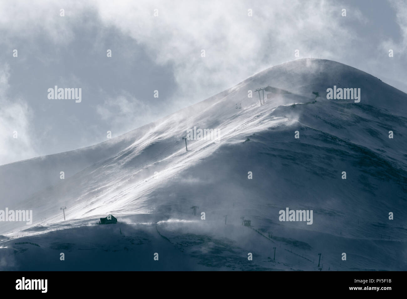 Severe winter weather blows snow over mountain peak Stock Photo - Alamy
