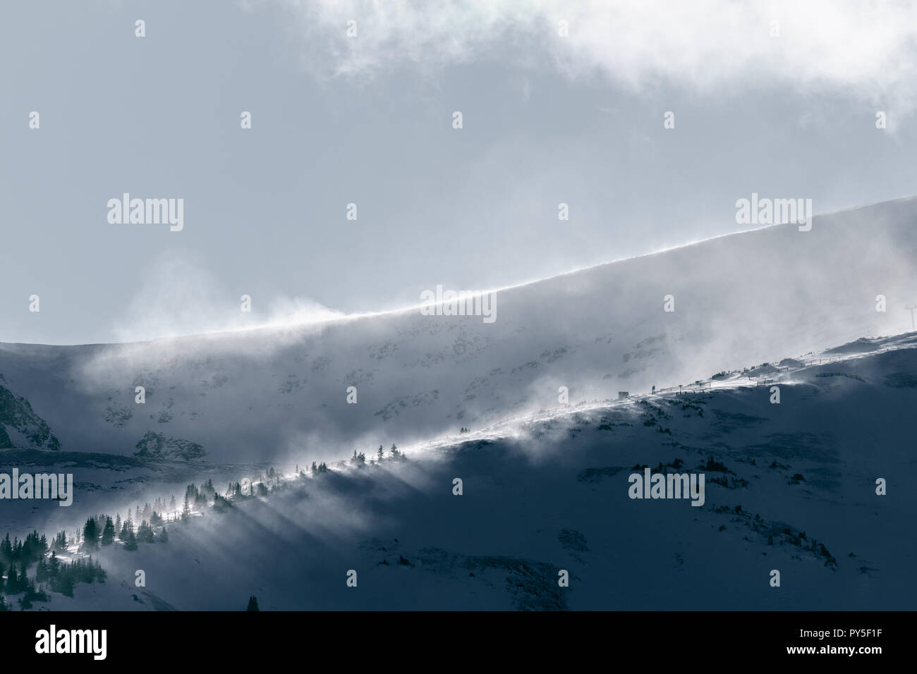 Severe winter weather blows snow over mountain peak Stock Photo - Alamy