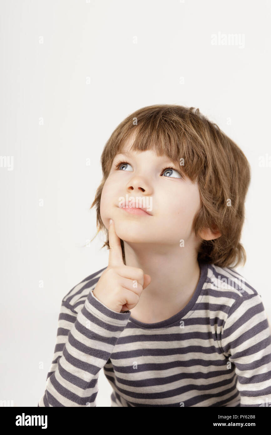 Smart little boy's portrait with serious thinking face the white ...