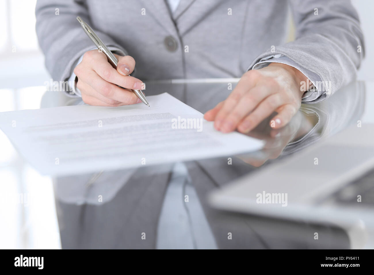 Close-up of female hands with pen over document, business concept ...