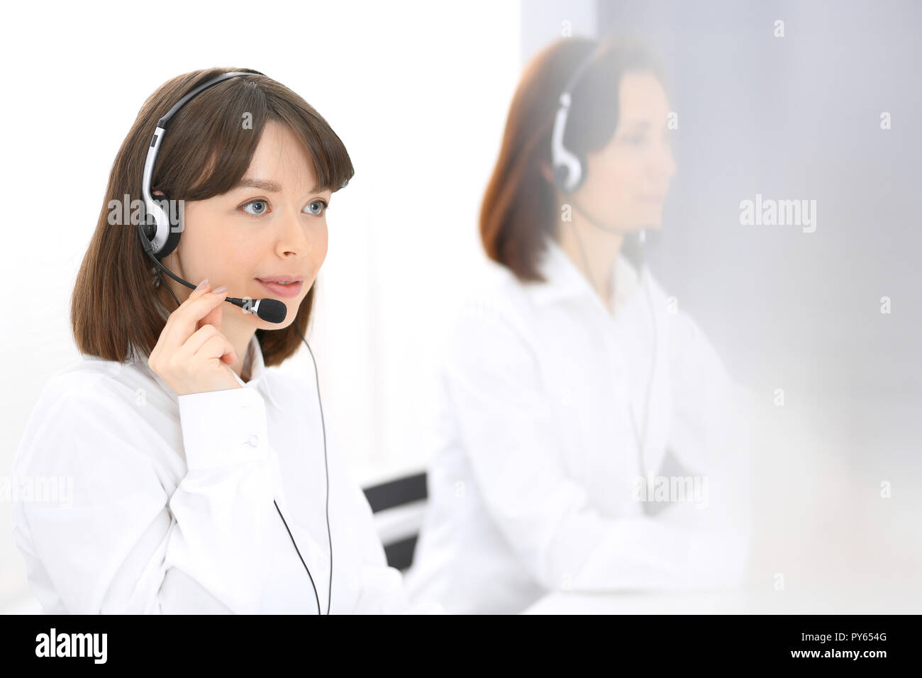 Call center. Group of operators at work. Focus on young brunette woman. Business concept Stock ...
