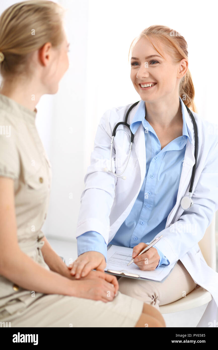 Doctor and patient having a pleasure talk while sitting at the chairs ...