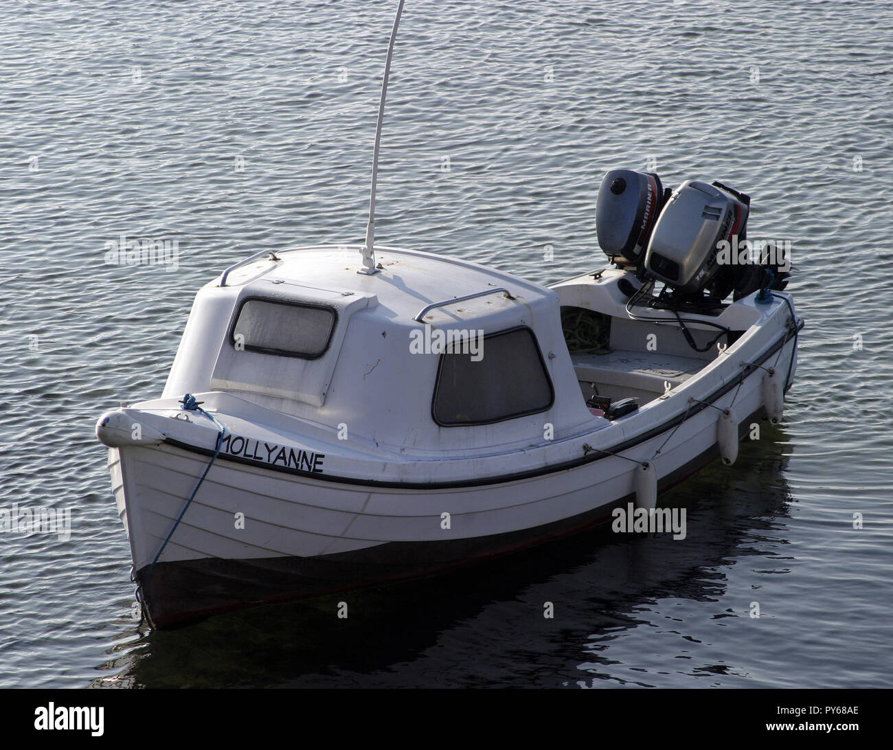 A little white motor boat called MOLLYANNE is moored in Portrush bay ...
