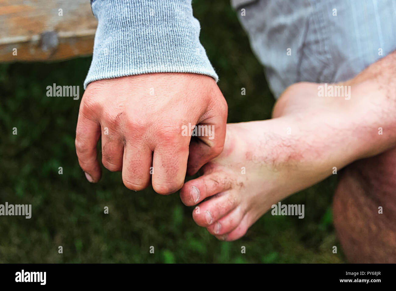 A hand holding onto a bare foot while sitting Stock Photo - Alamy