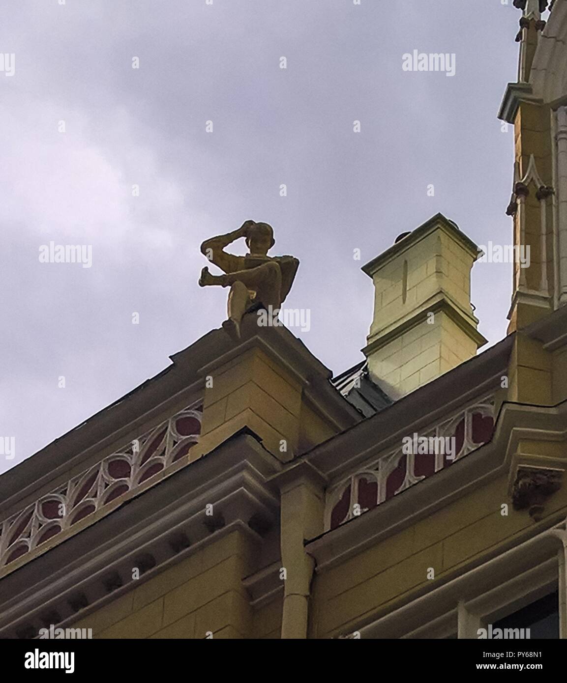 Statue of reading boy on the house roof in Riga, Latvia Stock Photo - Alamy