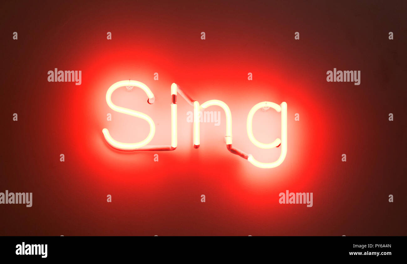 Neon sign - Shining over a white wall - Sing Stock Photo - Alamy