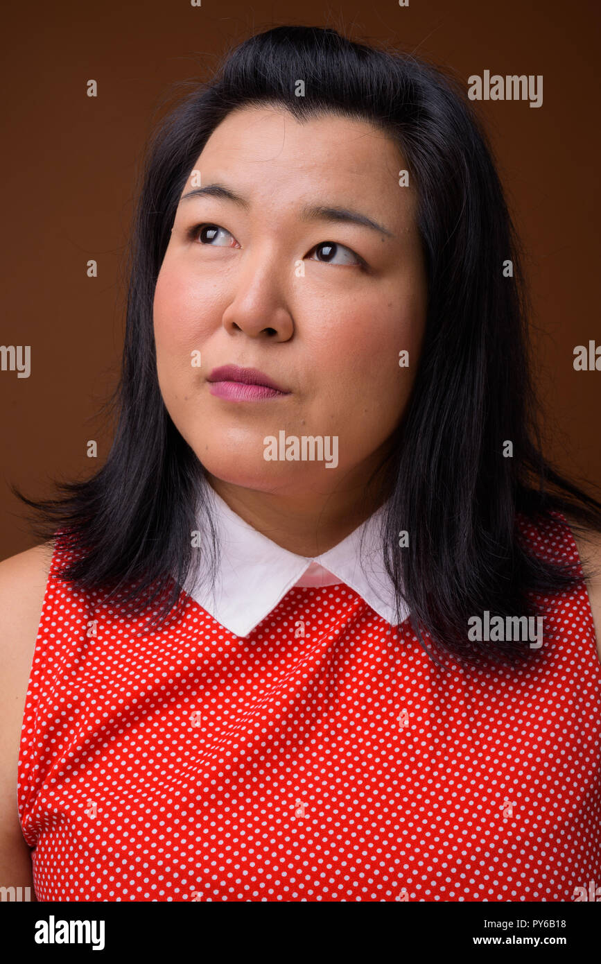Face of beautiful overweight Asian woman thinking Stock Photo - Alamy