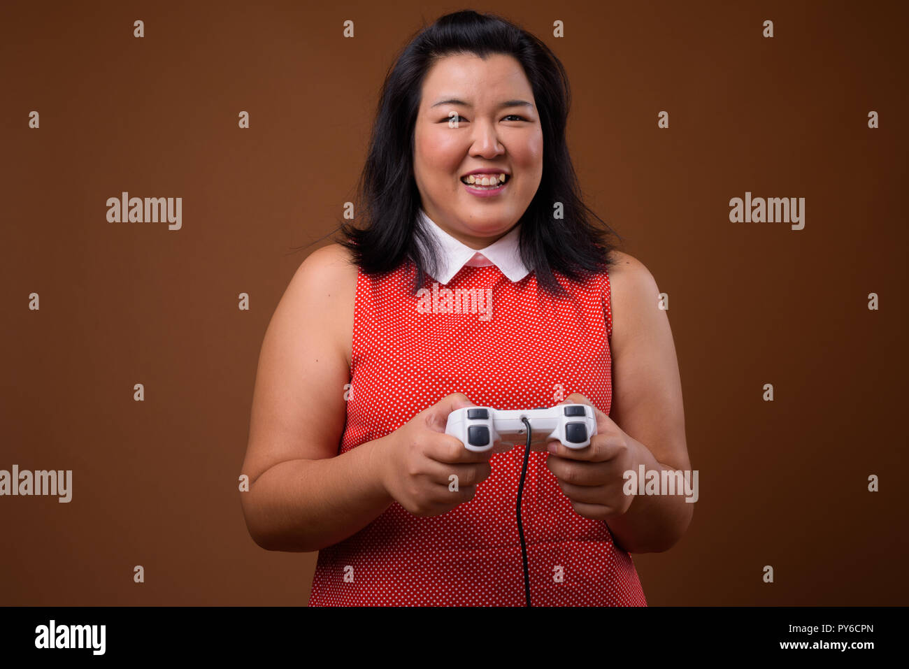 Beautiful overweight Asian woman playing video games using game ...