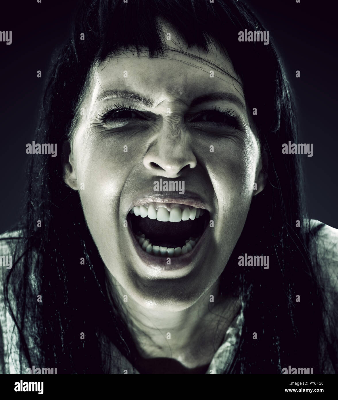 Halloween horror. Crazy bloody scary zombie woman looks into the camera ...