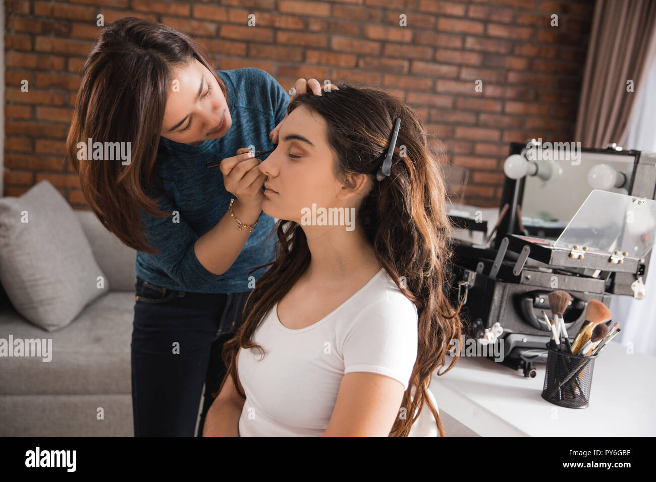 Make-up process, the face of a beautiful young woman and makeup artist ...