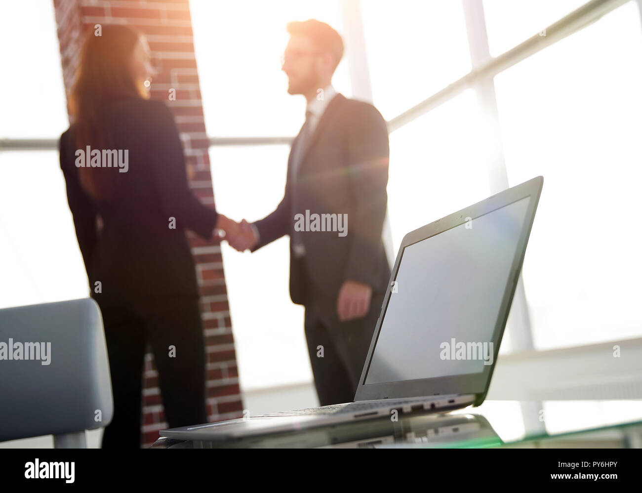 laptop on the desk, background handshake Stock Photo - Alamy