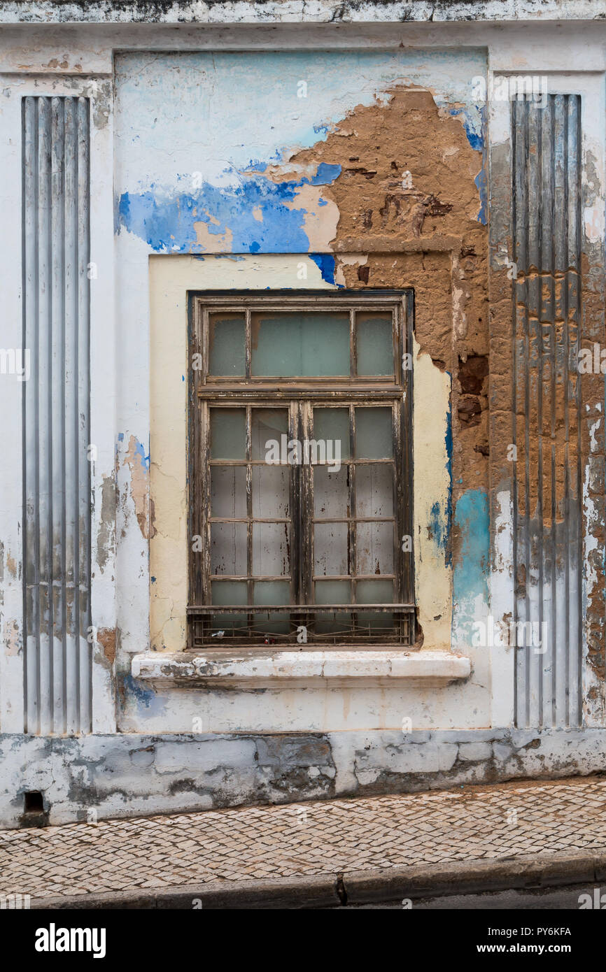 Wall of an abandoned house with white facade and several tones of blue ...