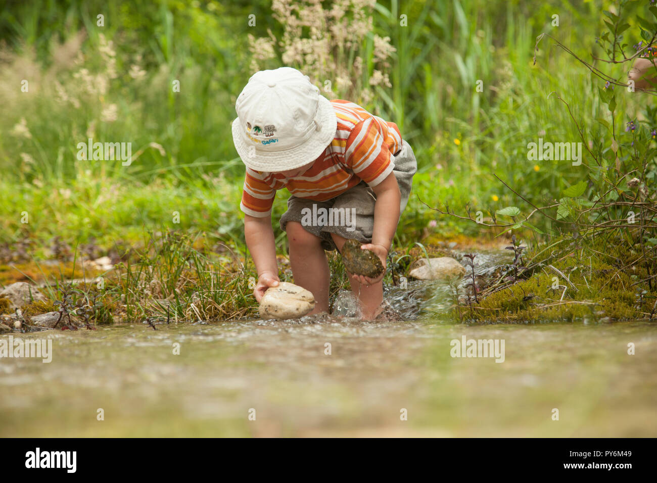 Little baby playing in stream Stock Photo - Alamy