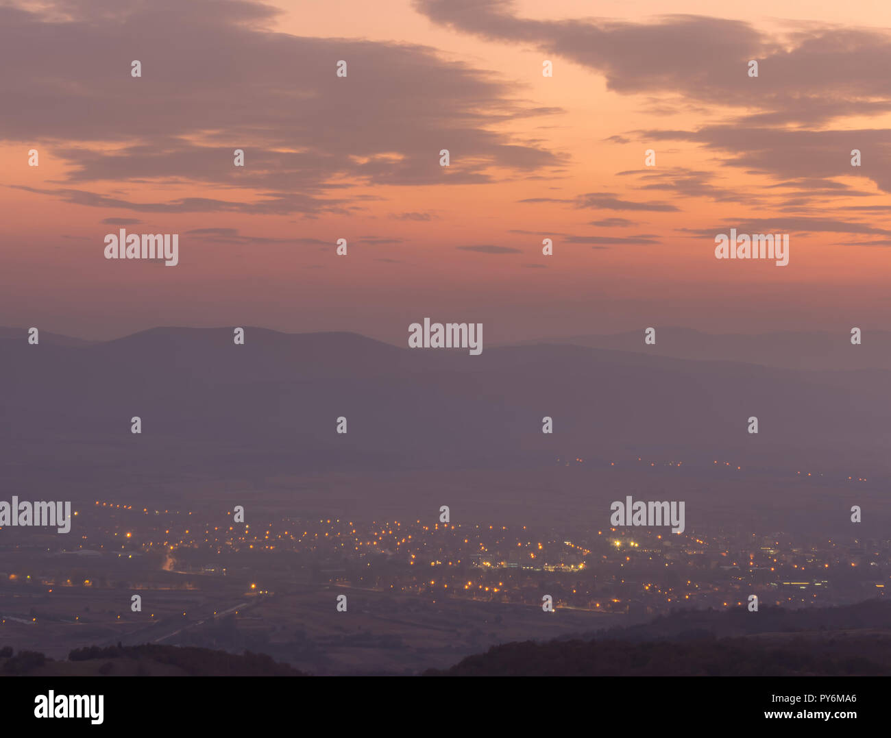 Dreamy, misty, distant cityscape and soft sunset sky and horizon ...