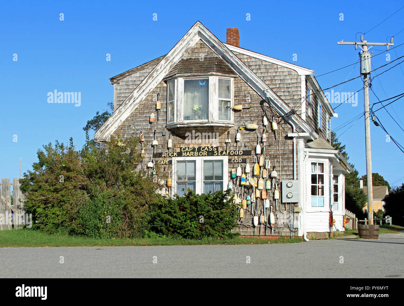 Wooden buoys hanging from shingled exterior side wall of Cap't Cass ...