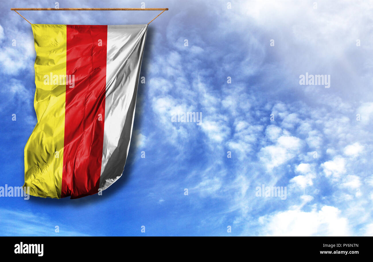 Flag of North Ossetia. Vertical flag, against blue sky with place for ...