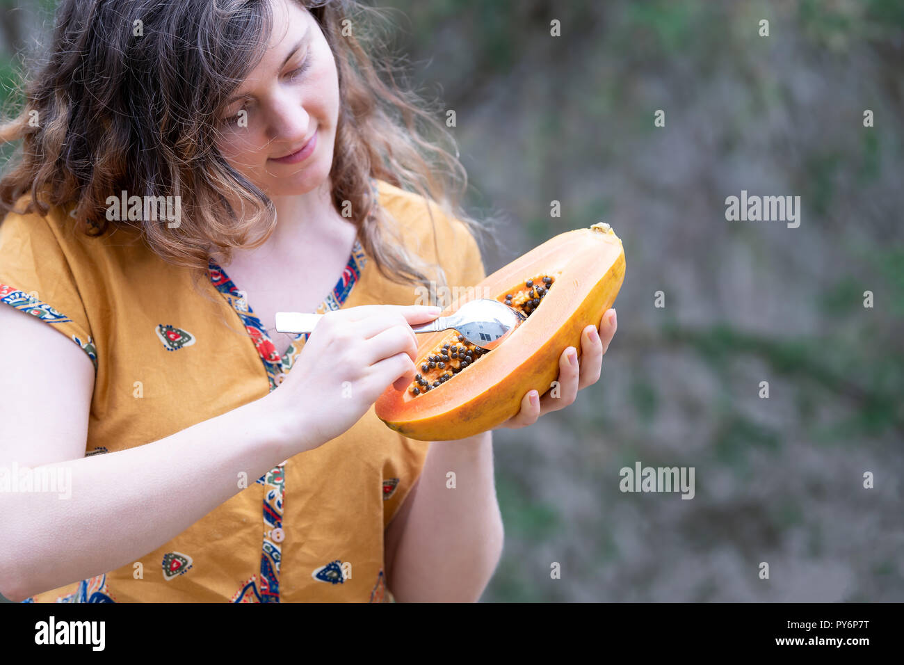 Closeup of attactive young woman showing, holding, removing seeds with ...