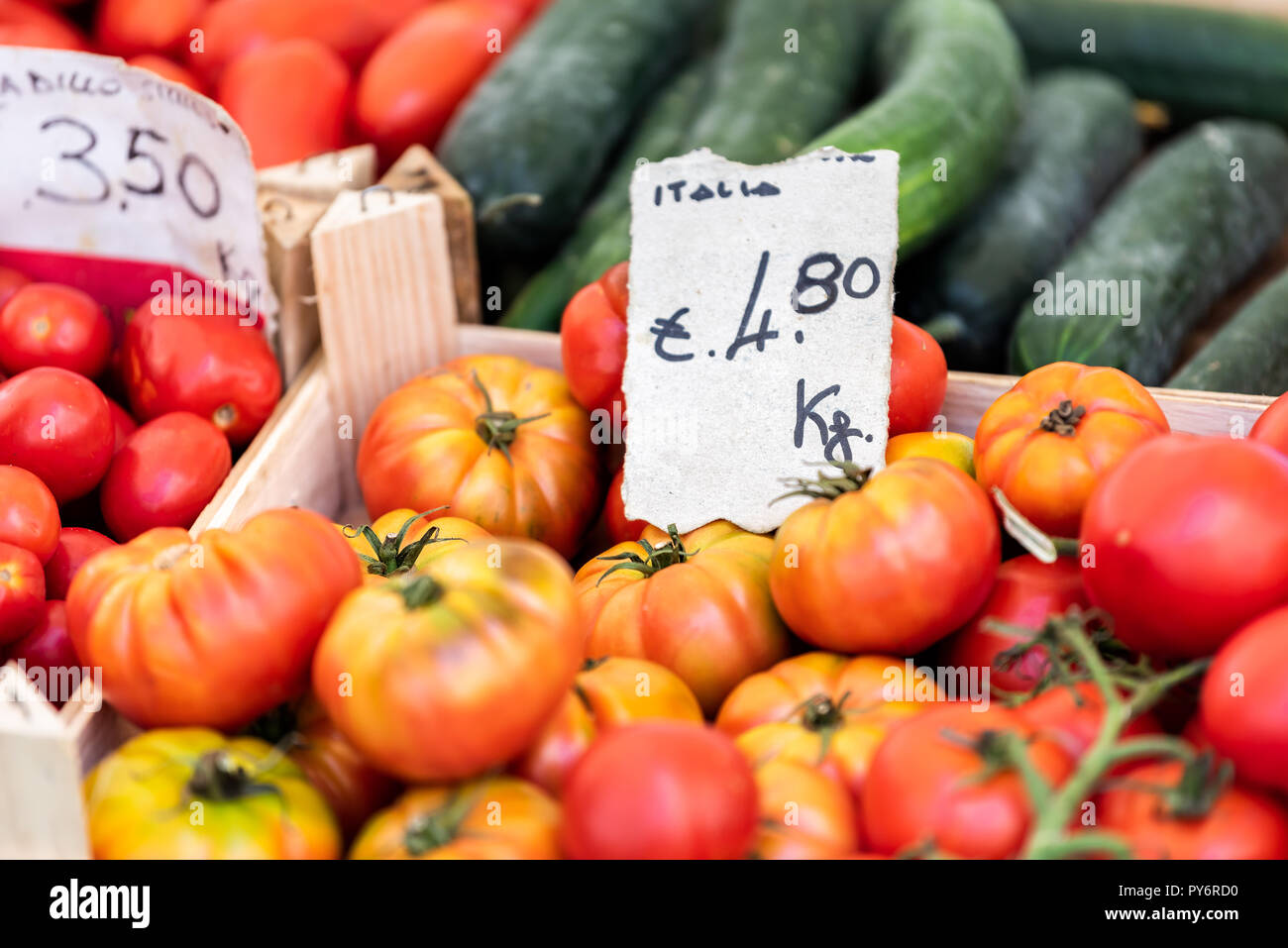 Closeup of many ripe red, yellow, heirloom tomatoes on display farmers ...