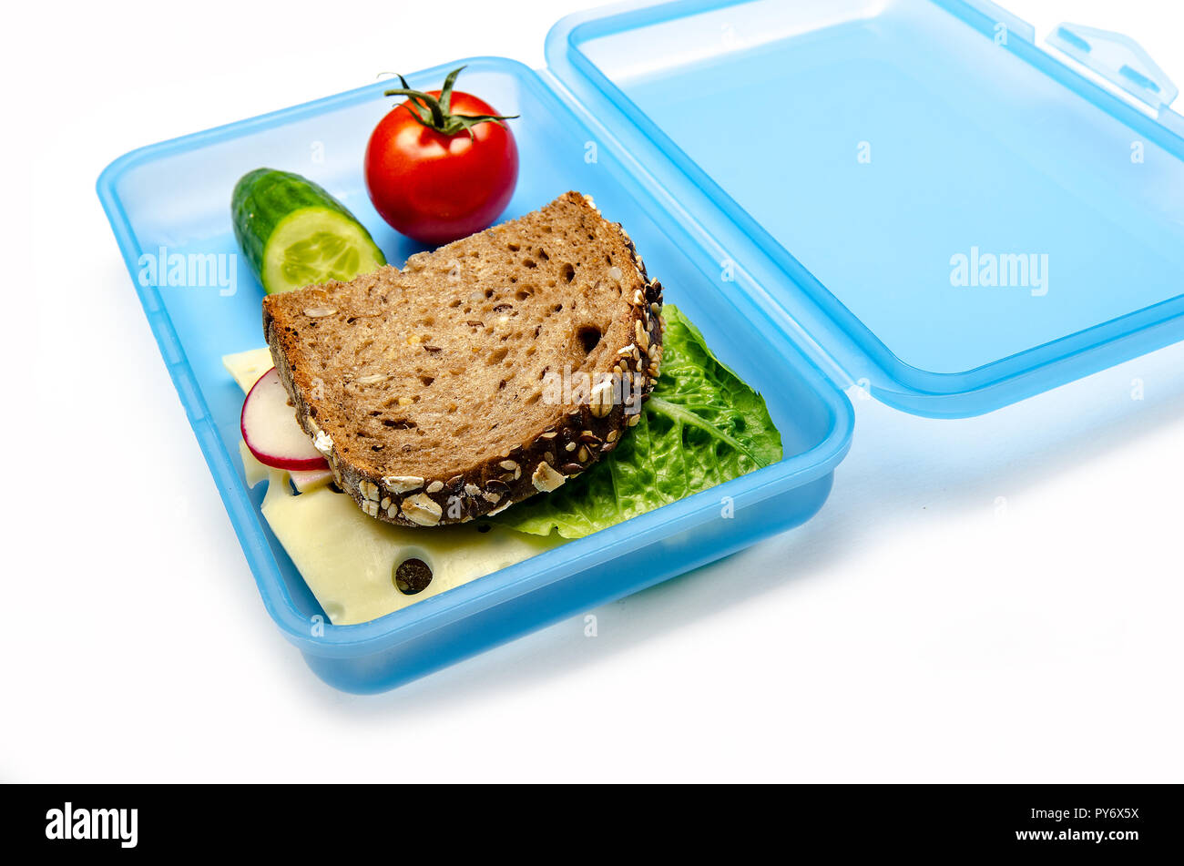blue lunch box with bread and vegetables on white background, isolated ...