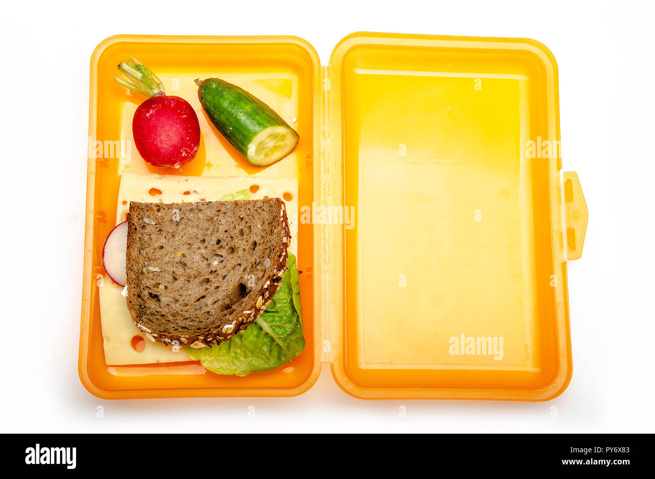 orange lunch box with bread and vegetables on white background ...