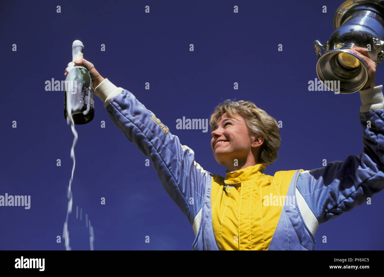 Blond female race car driver poses with winning trophy, USA Stock Photo ...