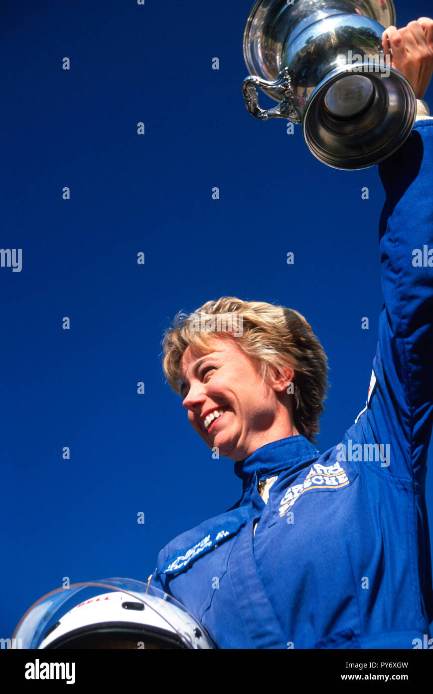 Blond female race car driver poses with winning trophy, USA Stock Photo ...