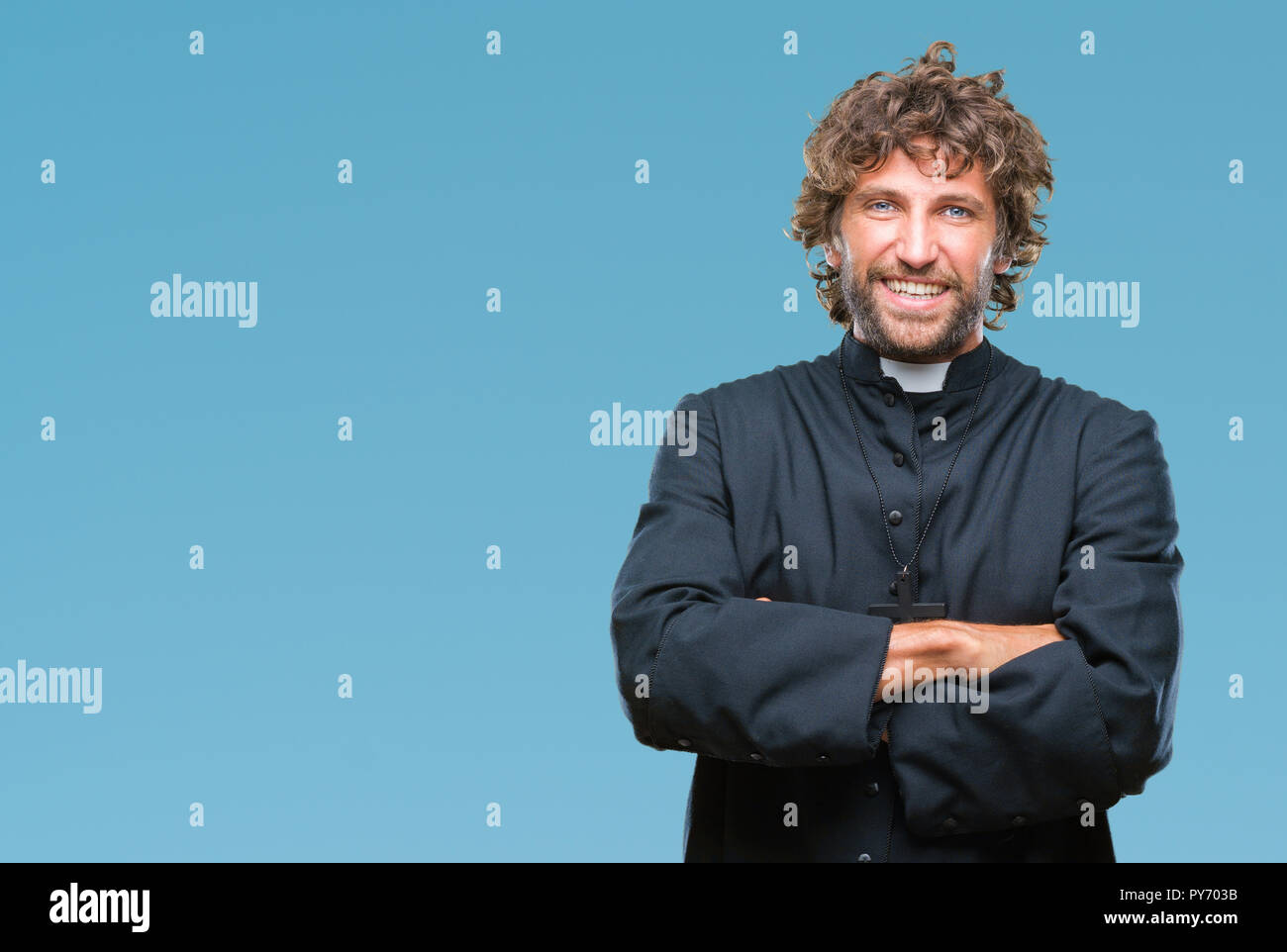 Handsome hispanic catholic priest man over isolated background happy ...