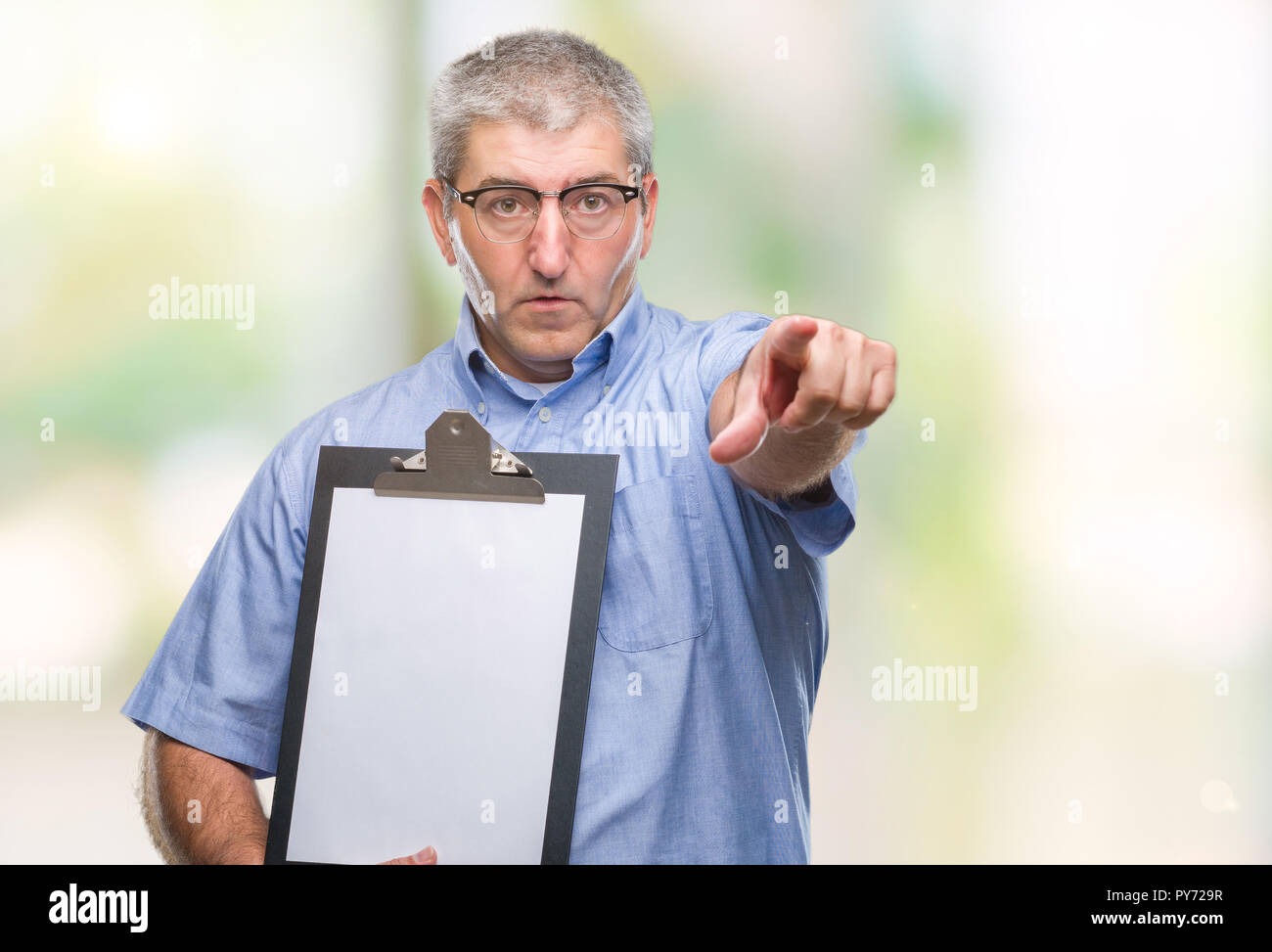 Handsome senior inspector man holding clipboard over isolated ...