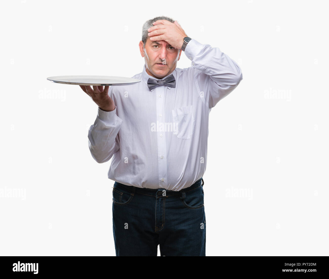 Handsome senior waiter man holding silver tray over isolated background ...