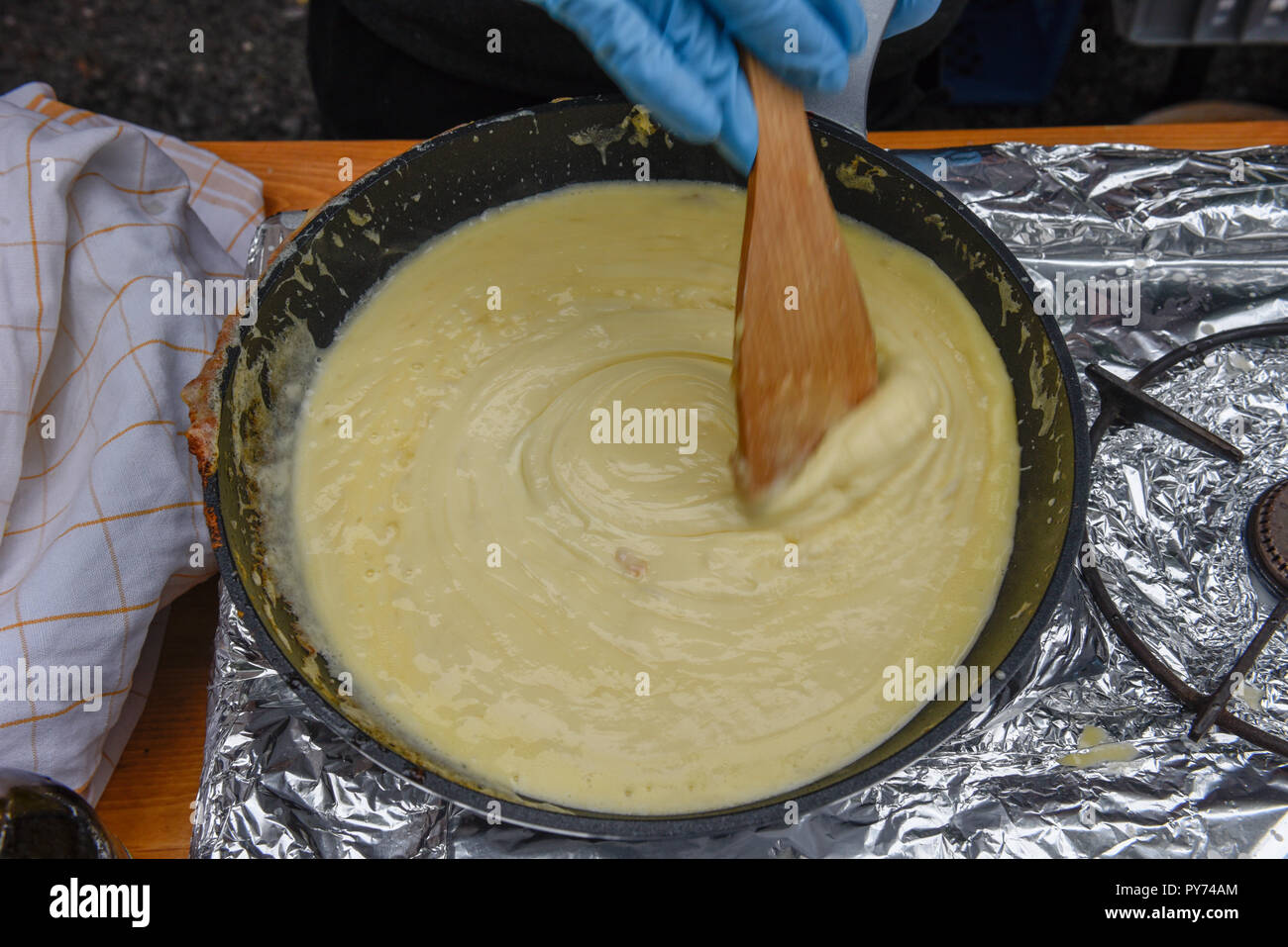 Preparation of traditional melted cheese in a pot on Switzerland Stock ...