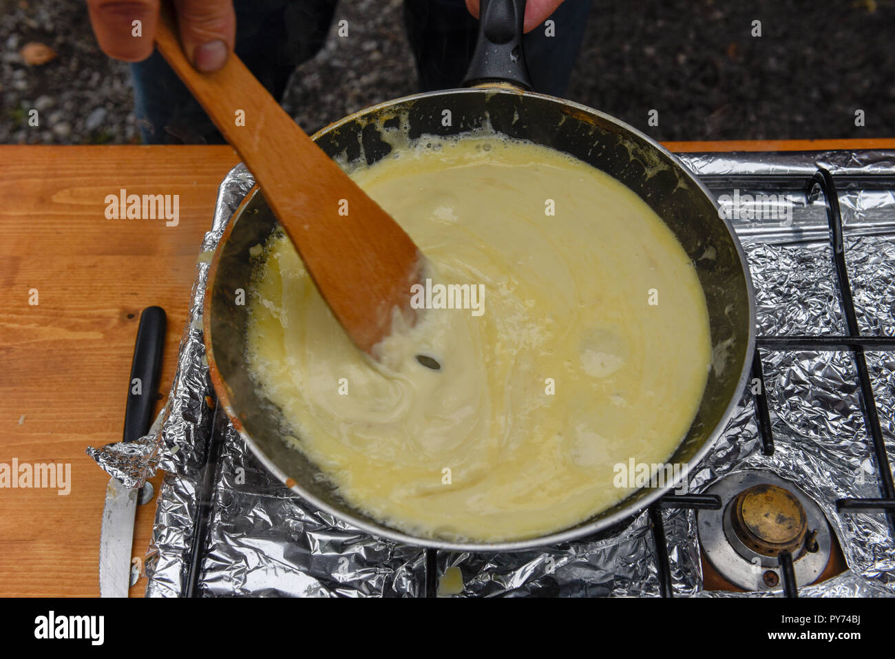 Preparation of traditional melted cheese in a pot on Switzerland Stock ...