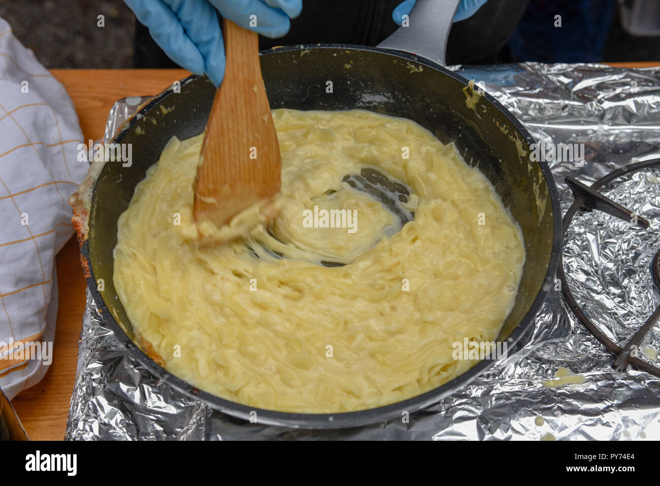 Preparation of traditional melted cheese in a pot on Switzerland Stock ...