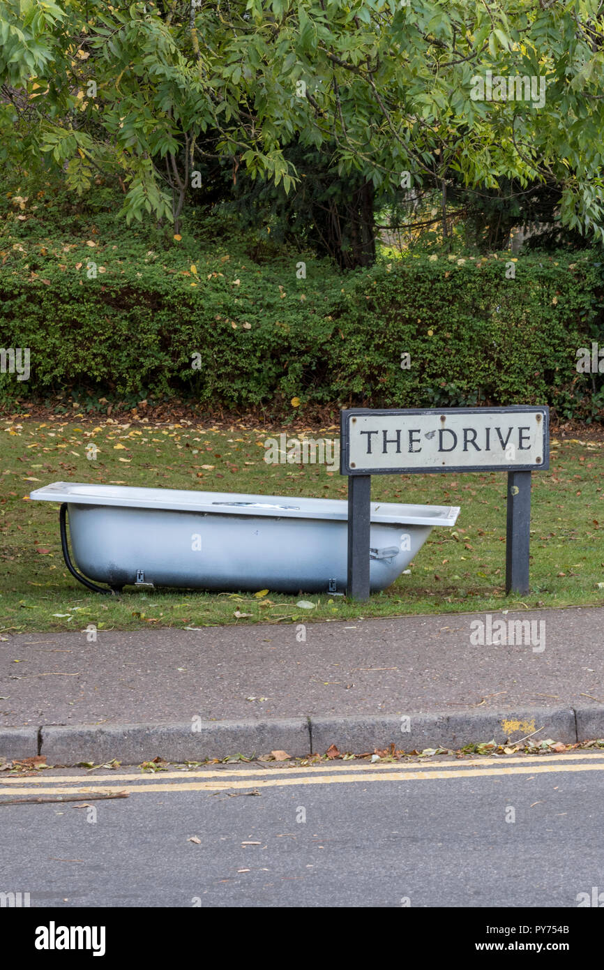 fly tipping discarded bath tub left on a grass verge in a tow. rubbish ...