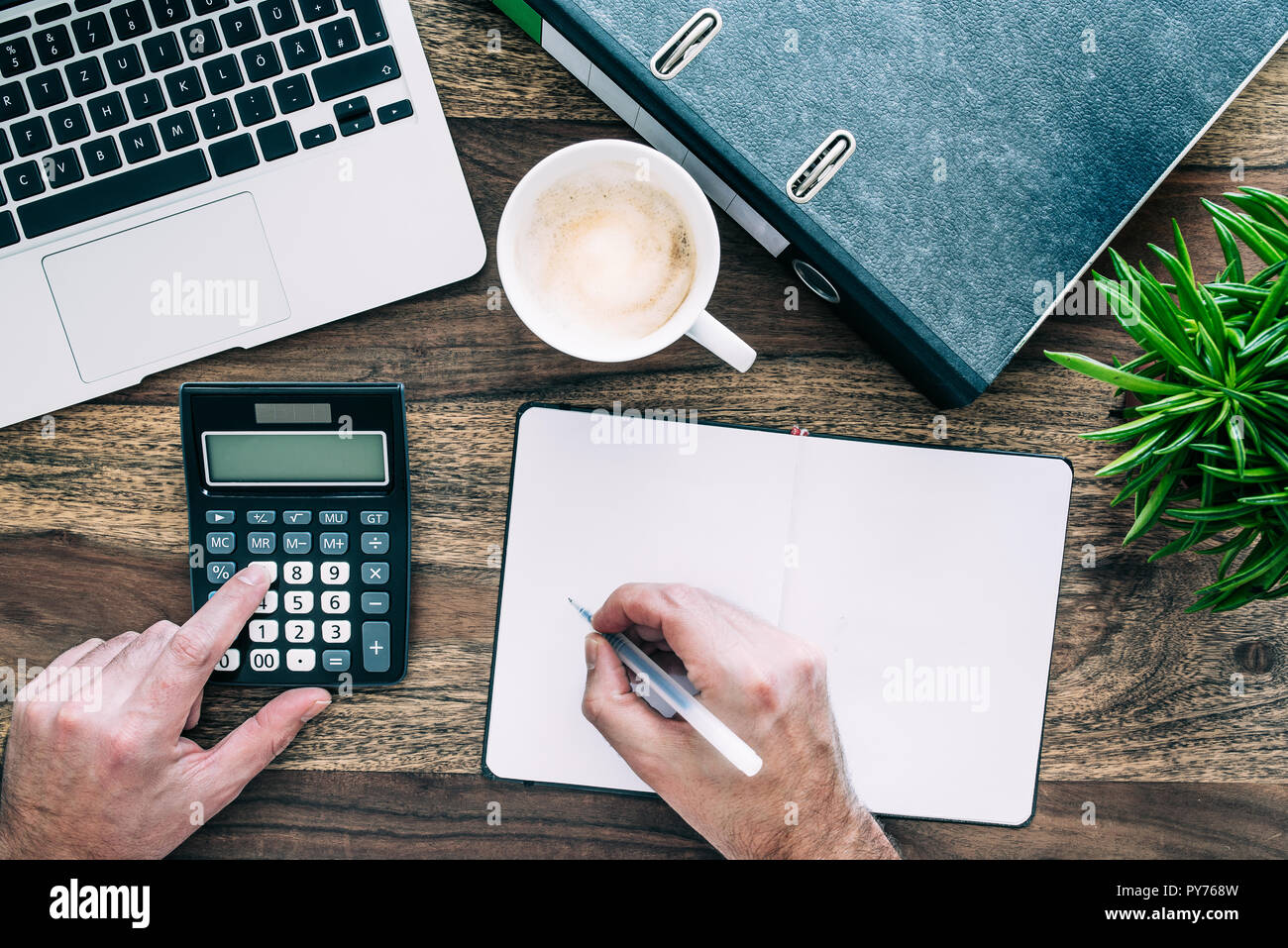top view of person using calculator and taking notes Stock Photo - Alamy