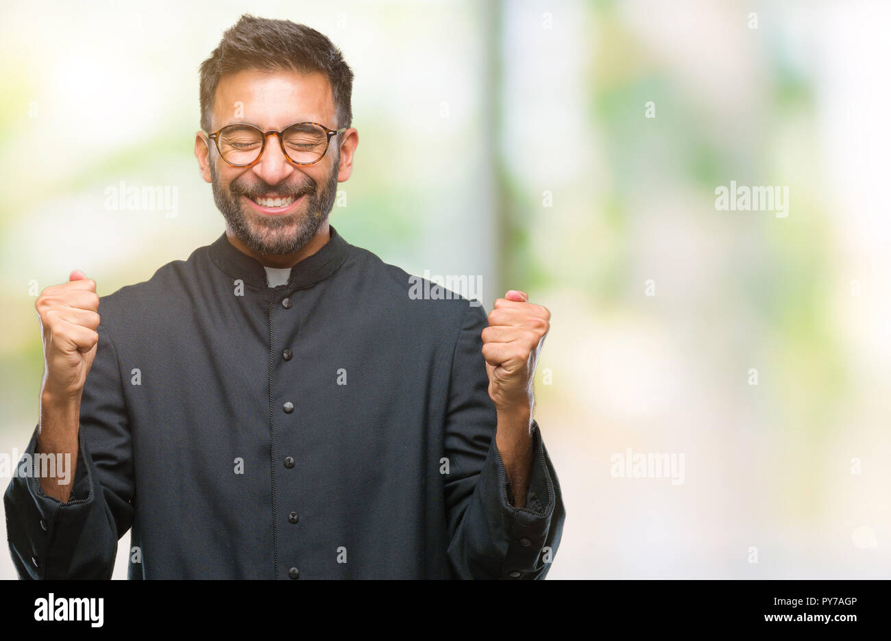 Adult hispanic catholic priest man over isolated background excited for ...