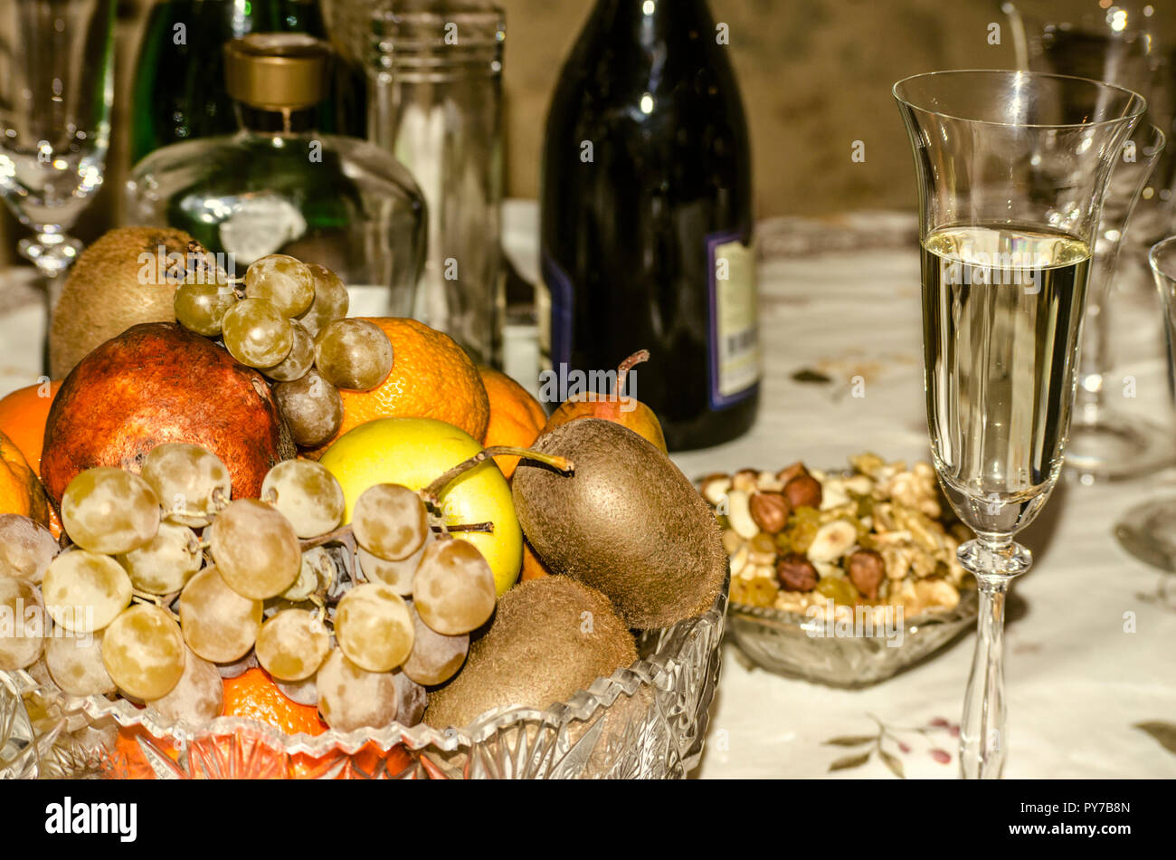 Fruits in a crystal vase, a glass of champagne,a saucer with nuts ...