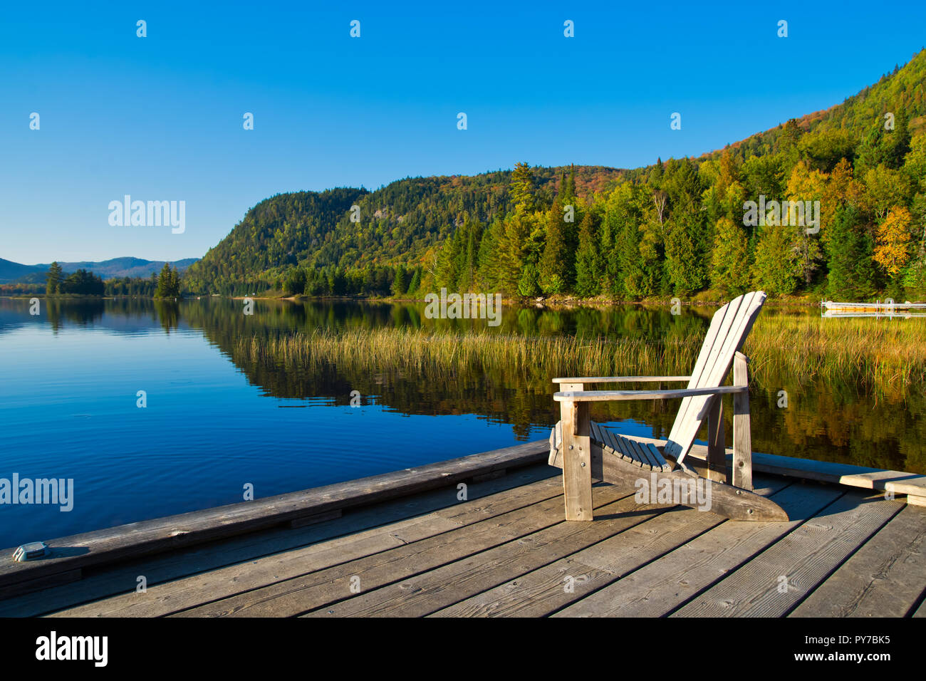 Wooden chair on lakeside pier Stock Photo - Alamy