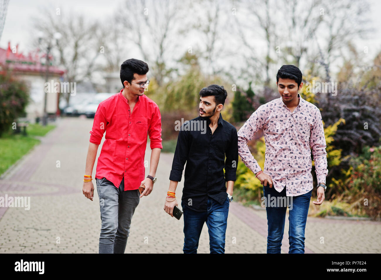 Three indian guys students friends walking on street Stock Photo - Alamy