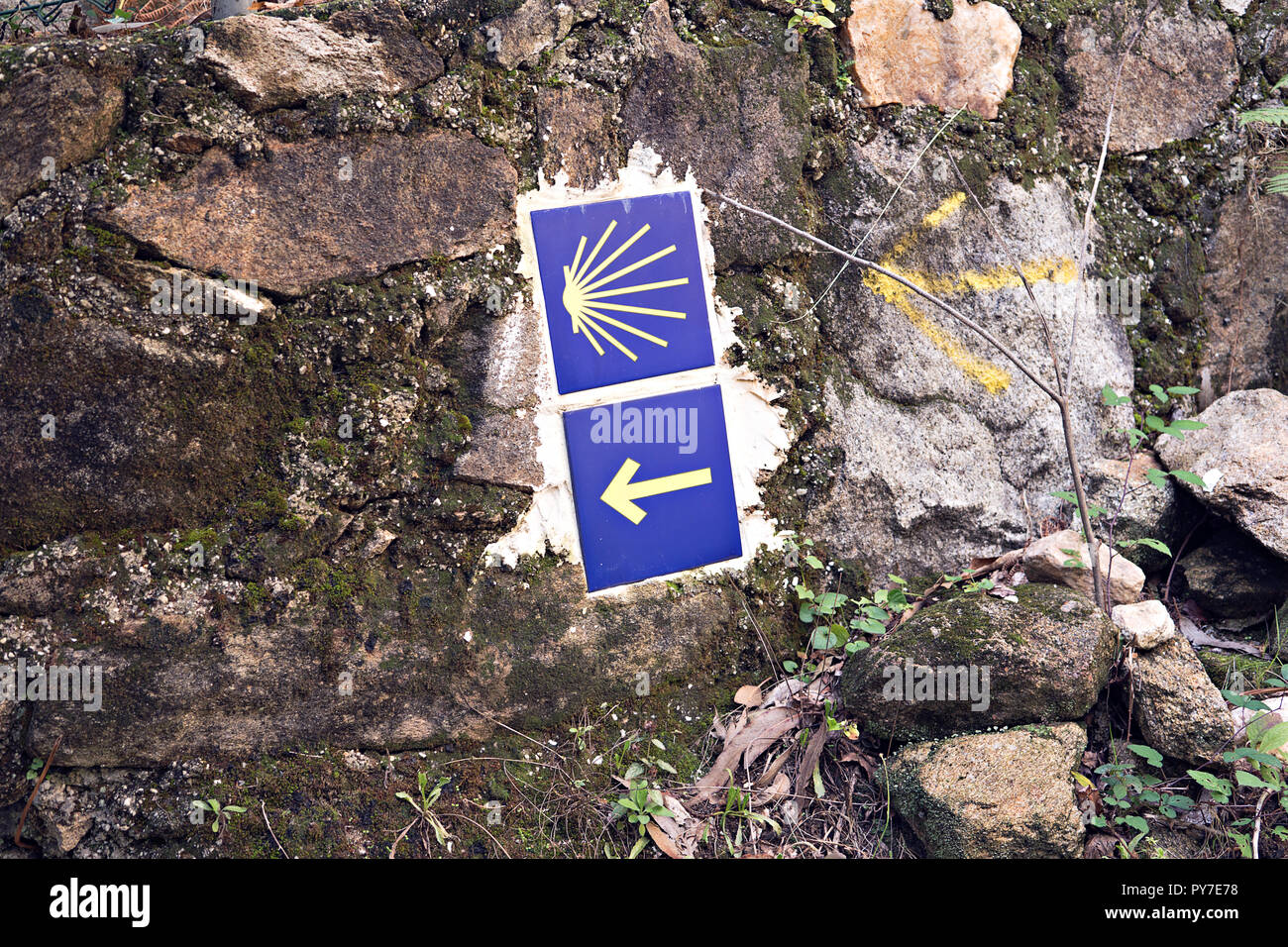 Camino de Santiago tiles on stone wall. Way of St. James signs. Arrow ...