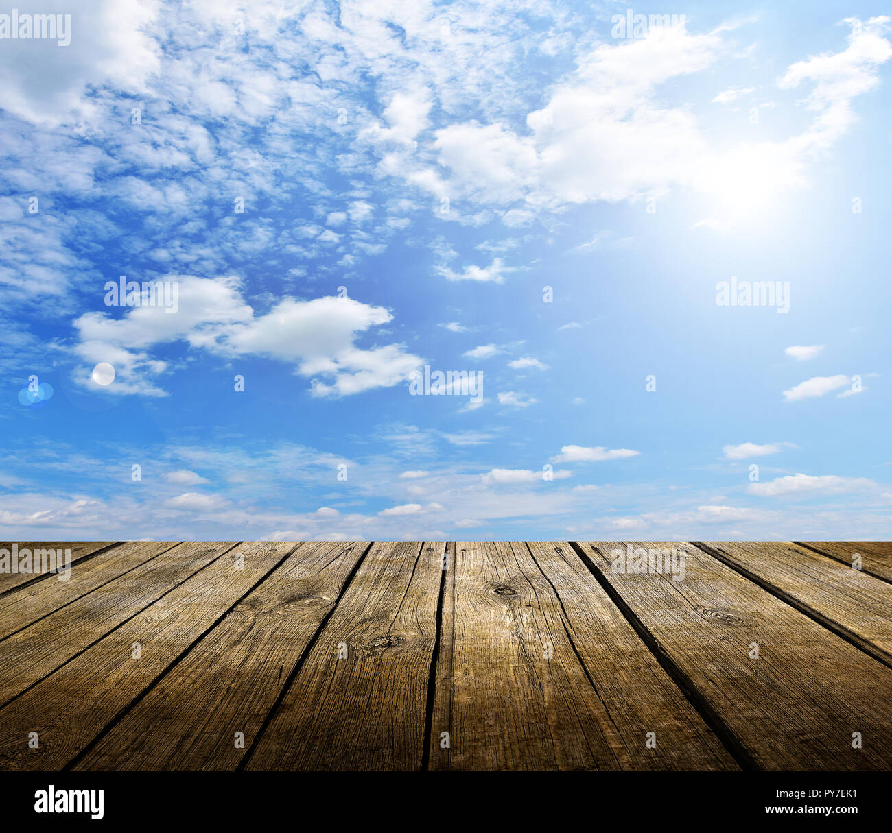 Empty wooden deck table with blue sky in background. Ready for product ...