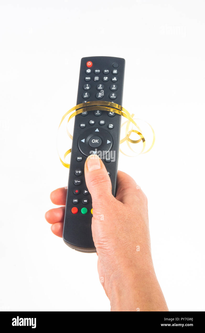 hand holding a remote control in a festive gold ribbon on white ...