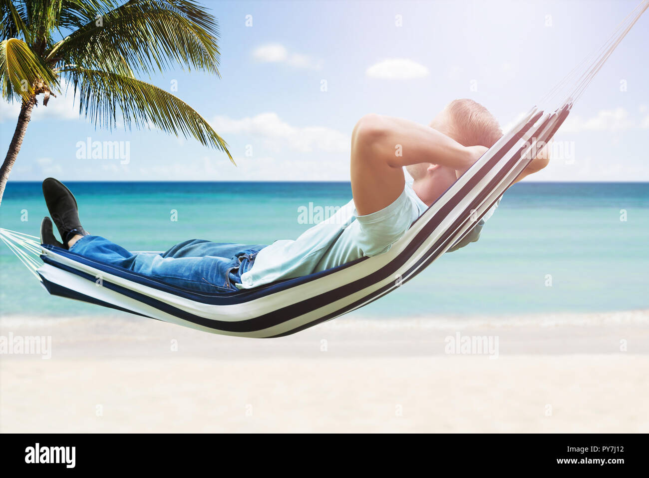 Man Relaxing In Hammock At Tropical Beach Stock Photo - Alamy