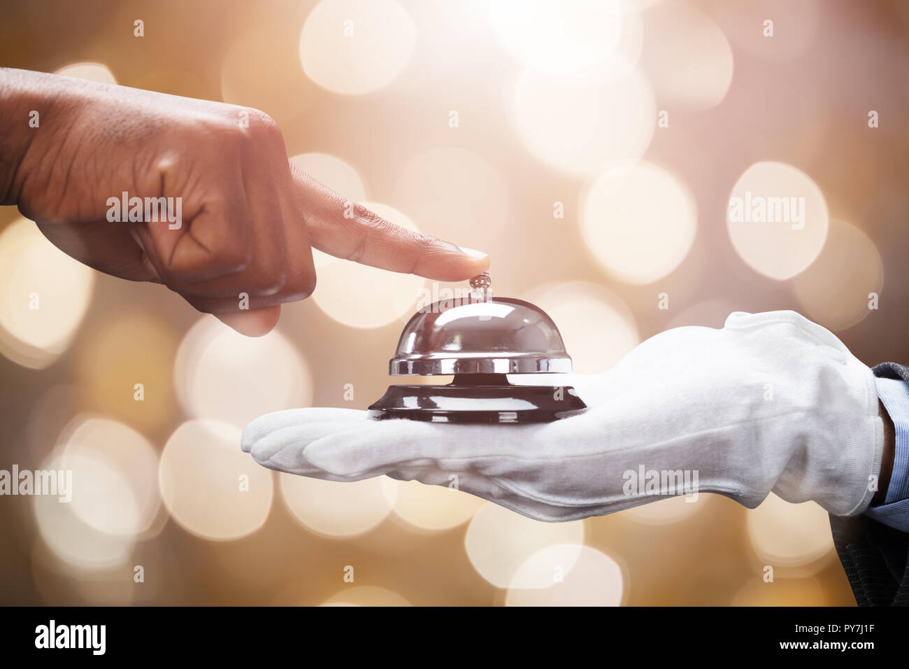 Customer's Hand Ringing Service Bell Held By Butler On Bokeh Background ...