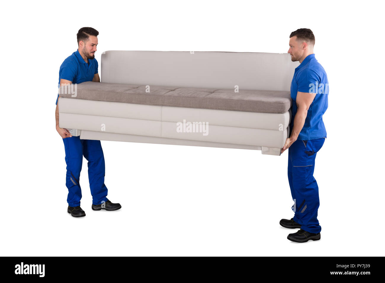 Two Young Male Movers Carrying Sofa On White Background Stock Photo - Alamy