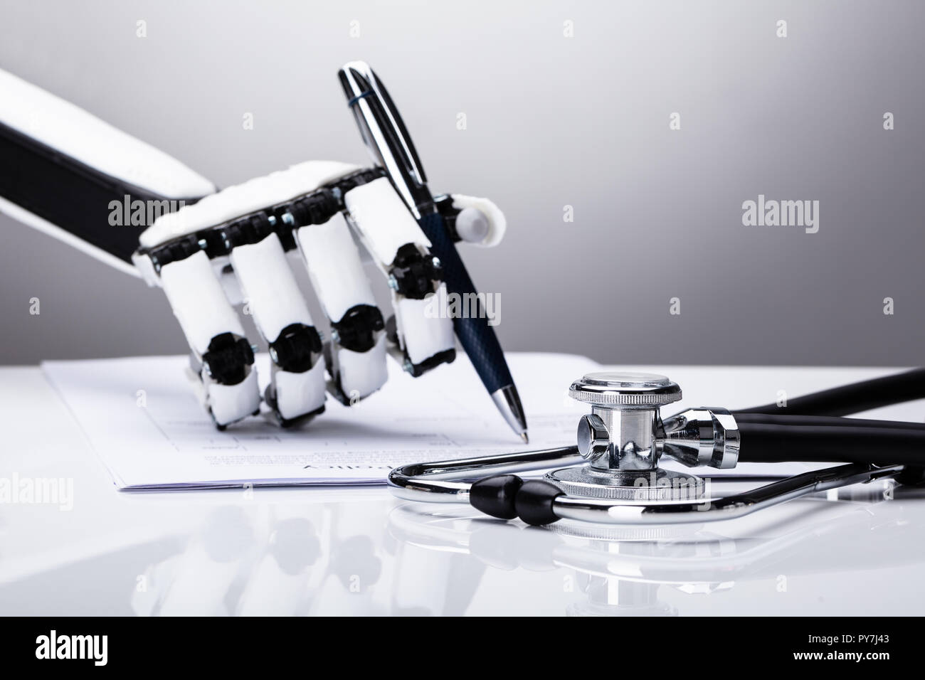 Robotic Hand Filling Form With Stethoscope Over Desk Stock Photo - Alamy